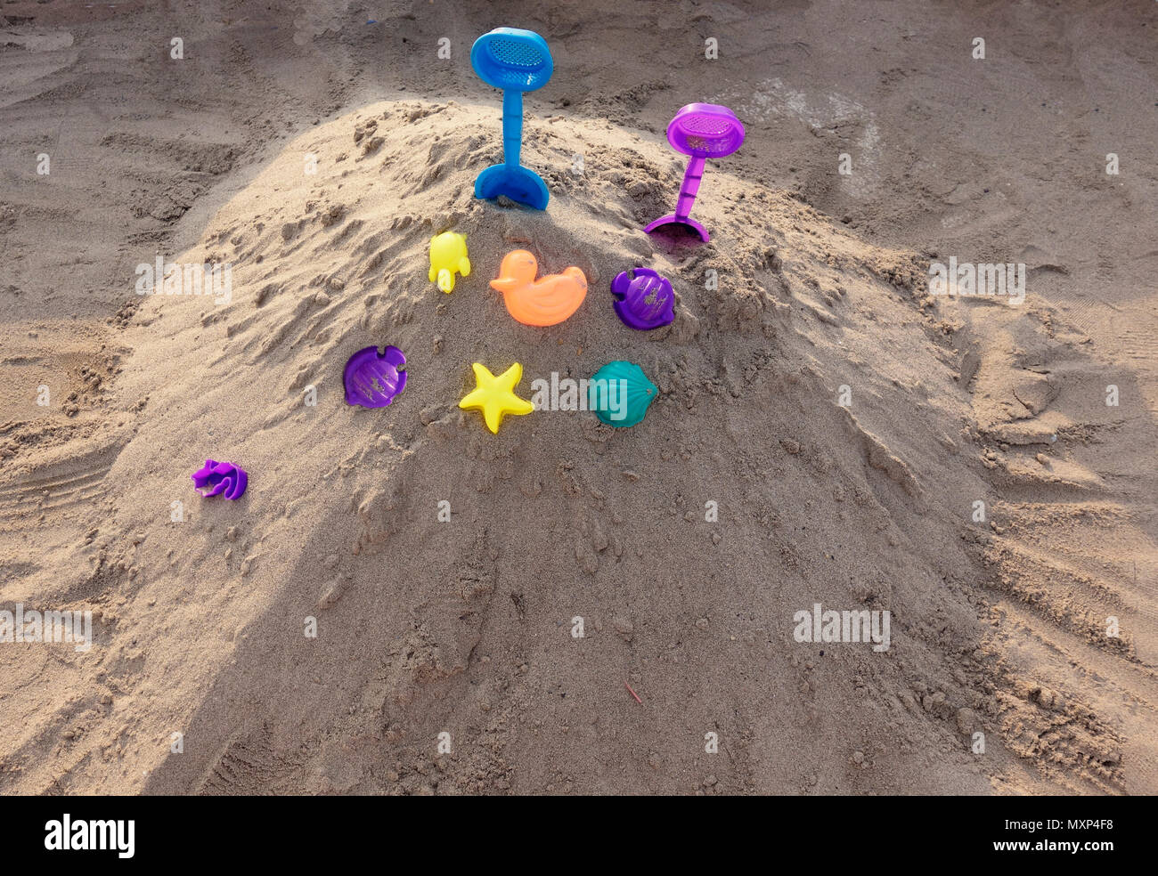 Sandcastle set on sand outdoors with plastic seashells, toy duck ...