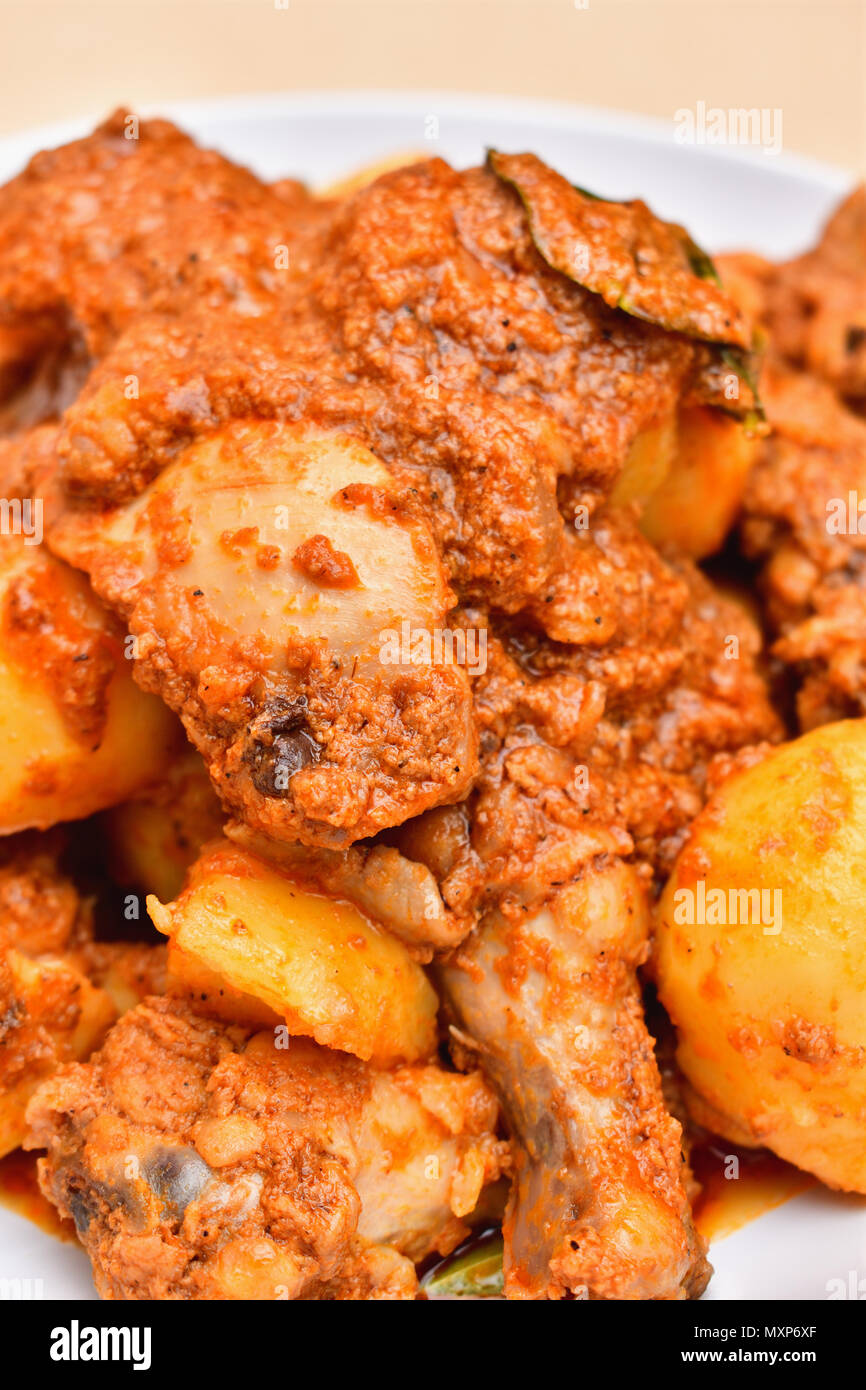 Chicken rendang with potatoes in think rendang curry sauce. A ...