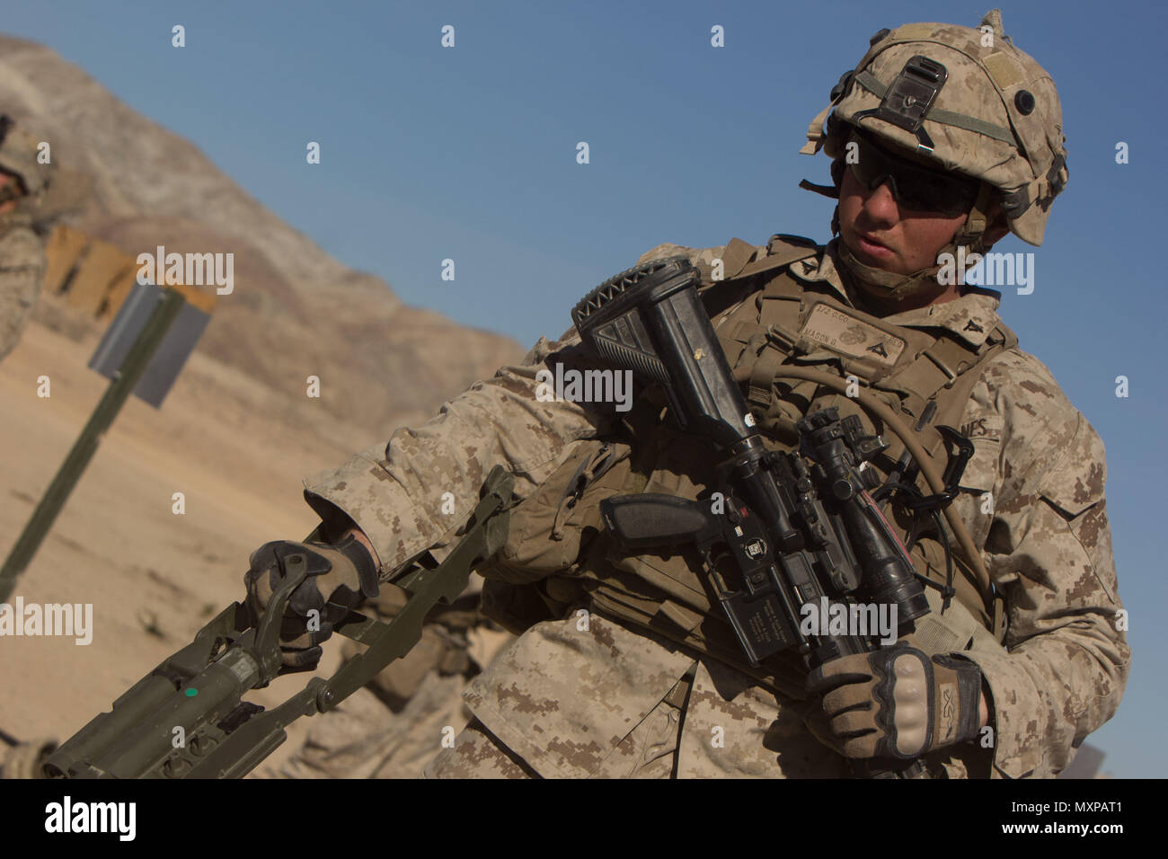 Lance Cpl. Garret Mason uses a metal detector to locate simulated ...
