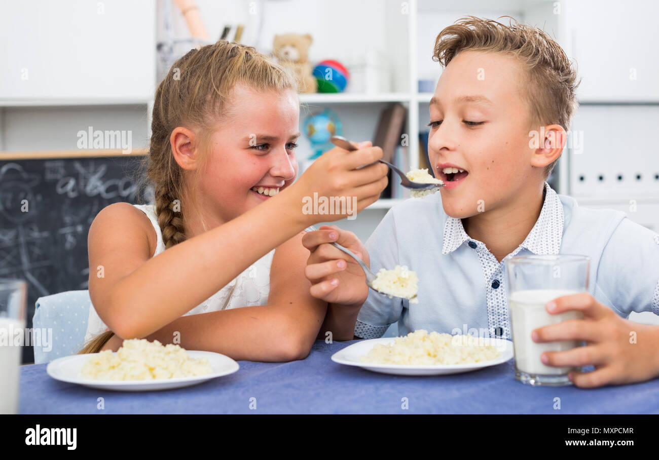 Sister with brother are playing with food at time lunch at home Stock ...