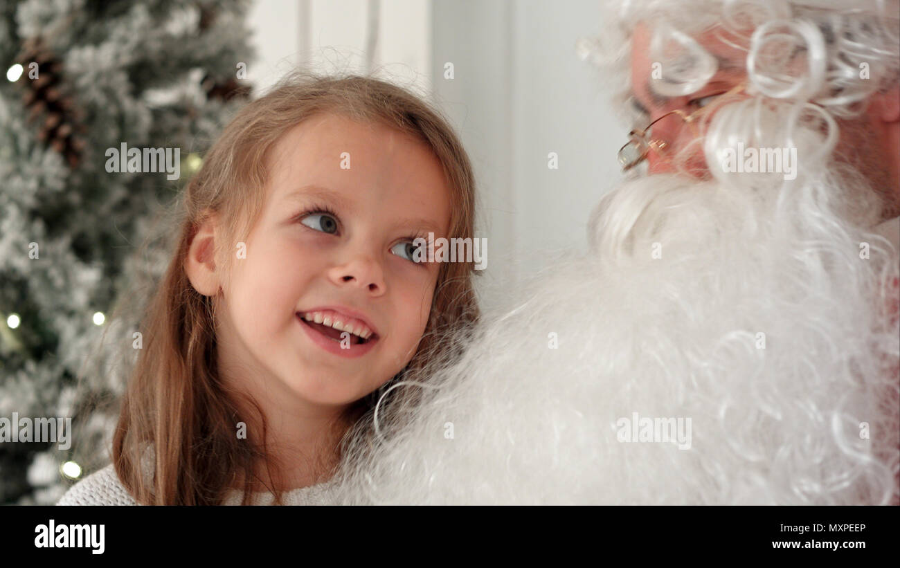 Cute little girl singing Christmas song together with Santa Claus Stock ...