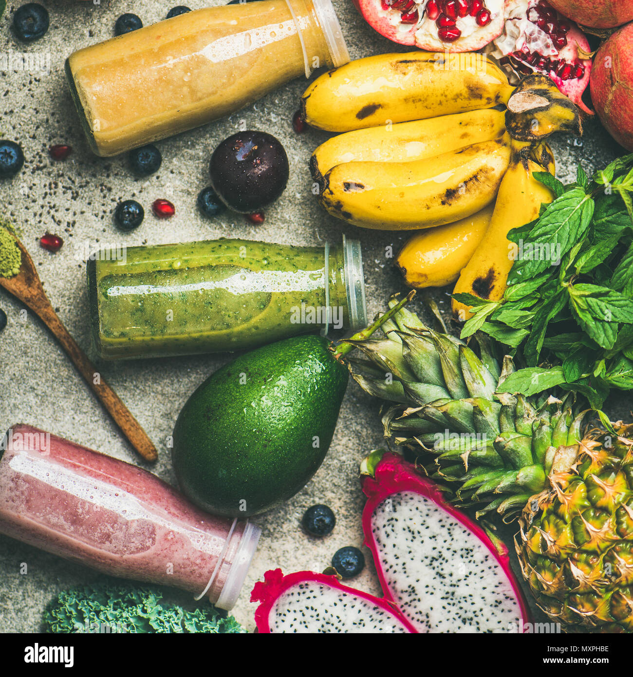 Colorful smoothies in bottles with fresh tropical fruit, square crop ...