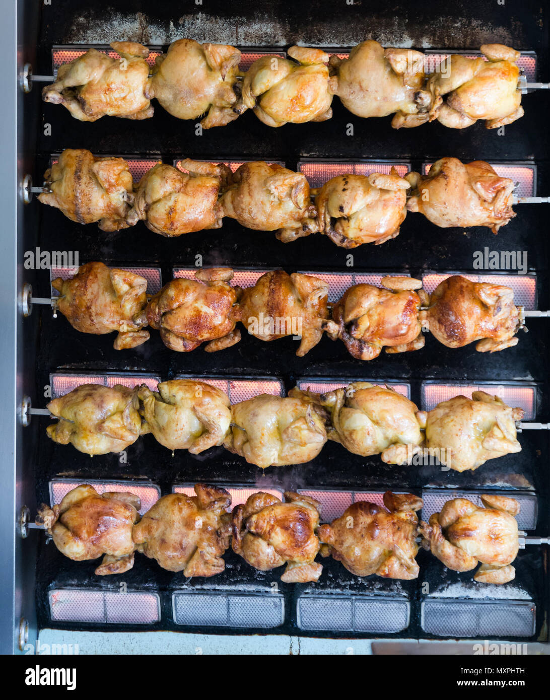 Fast food display of grill with poultry roasting on spit Stock Photo ...