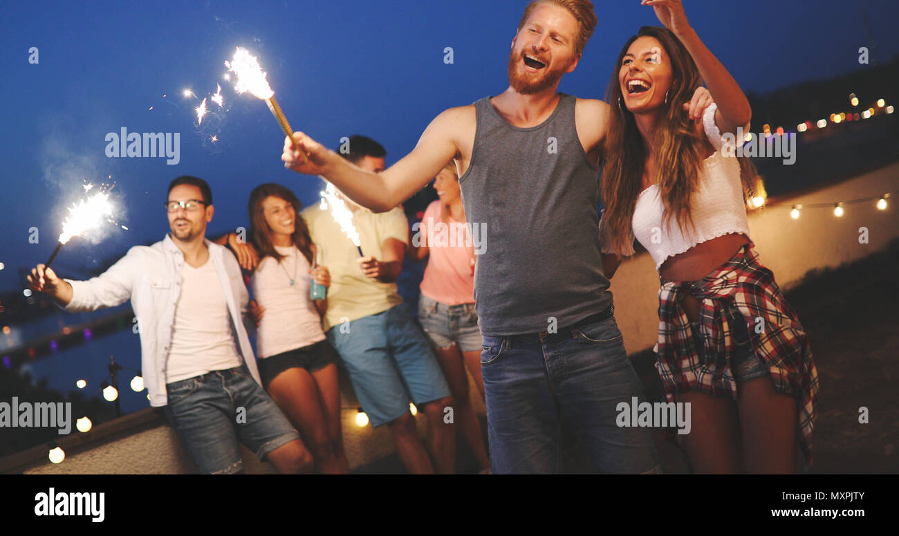 Happy friends lighting sparklers and enjoying freedom Stock Photo - Alamy
