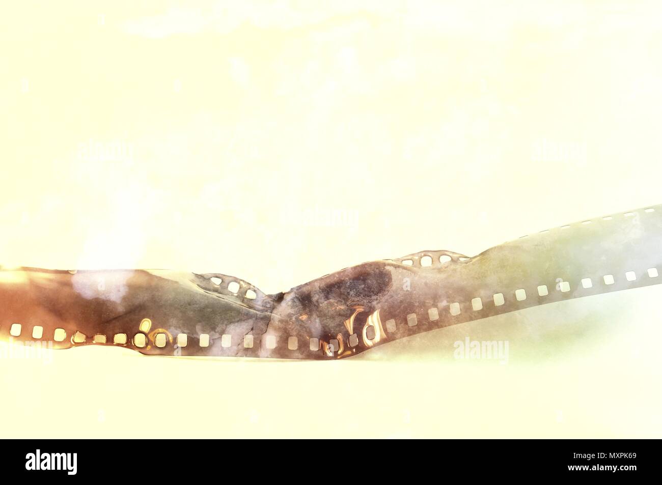 Twisted and burned film strip on yellow background. Vintage style Stock ...