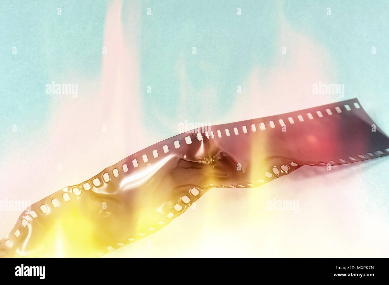 Twisted and burned film strip on blue background. Fire and flames ...