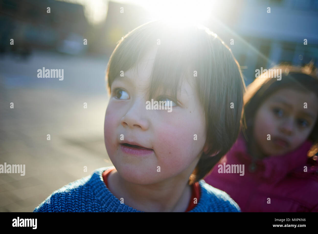 Portrait of two Asian friends at a playground in winter sunshine during ...