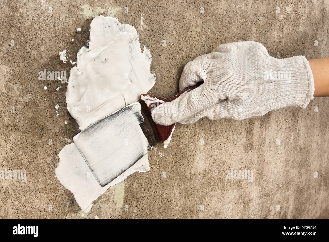 hand in glove plastering concrete wall with spatula Stock Photo - Alamy