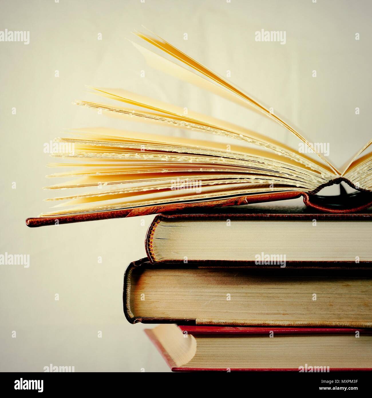 Stack of old books with open book Stock Photo - Alamy