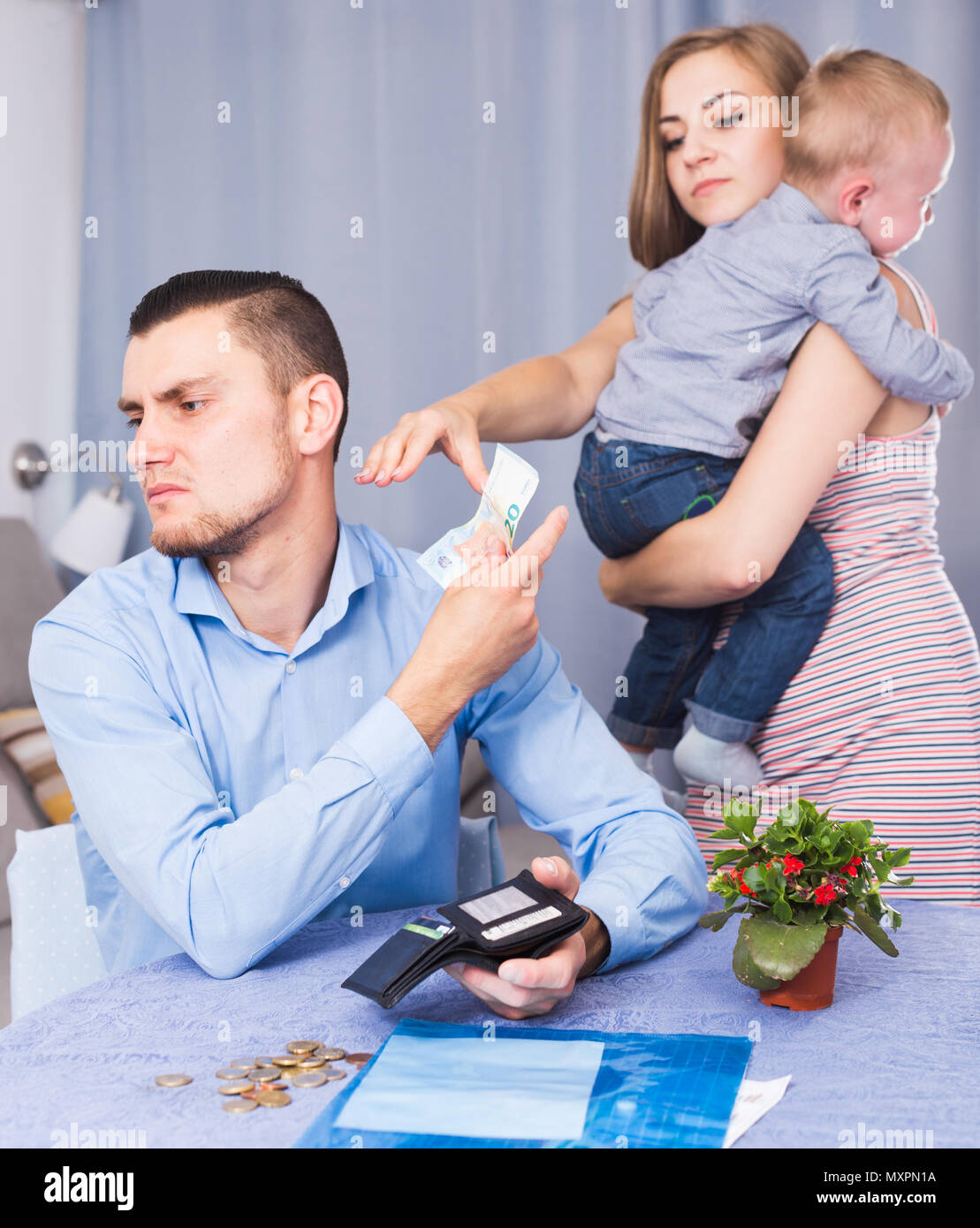 Angry female with child extorting money from male with hate indoors ...