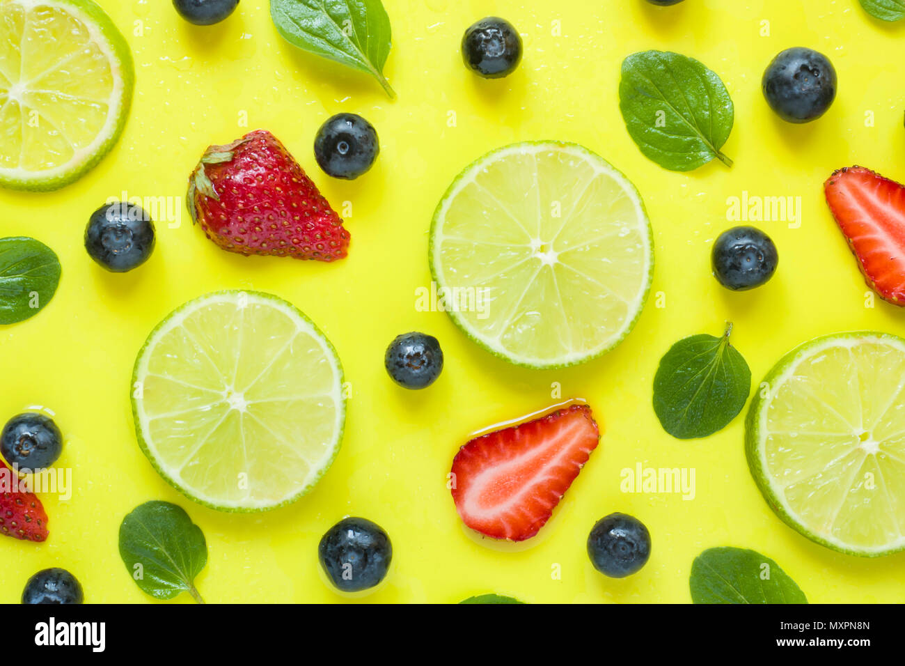 Bright summer yellow background with slices of citrus lime mint ...