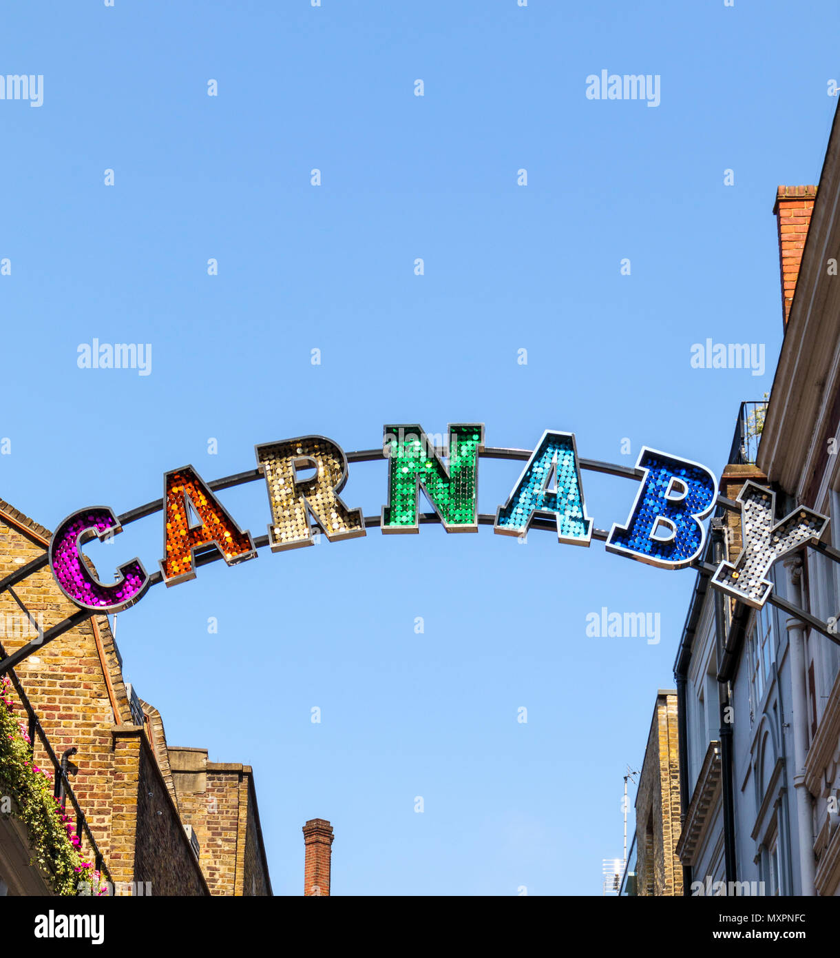 Glittering, colourful sign at the entrance to the iconic Carnaby Street ...