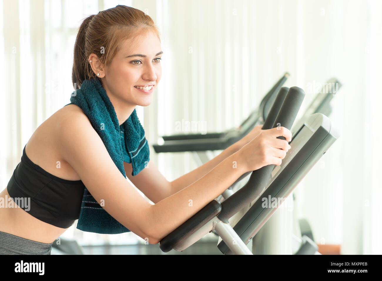 Older woman on exercise bike hi-res stock photography and images - Alamy