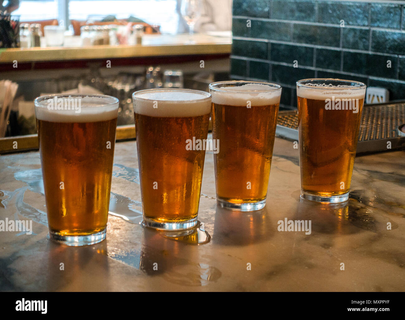 Beer glasses on a bar top Stock Photo - Alamy