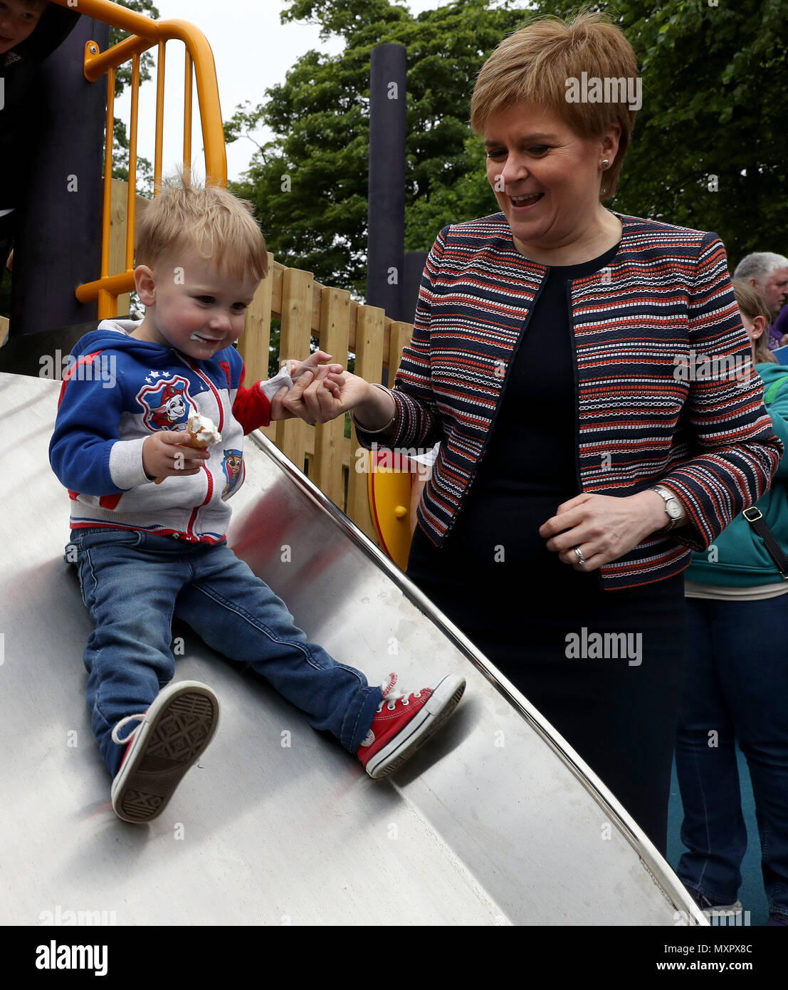 First Minister Nicola Sturgeon helps Jamie McGuiness down a slide as ...
