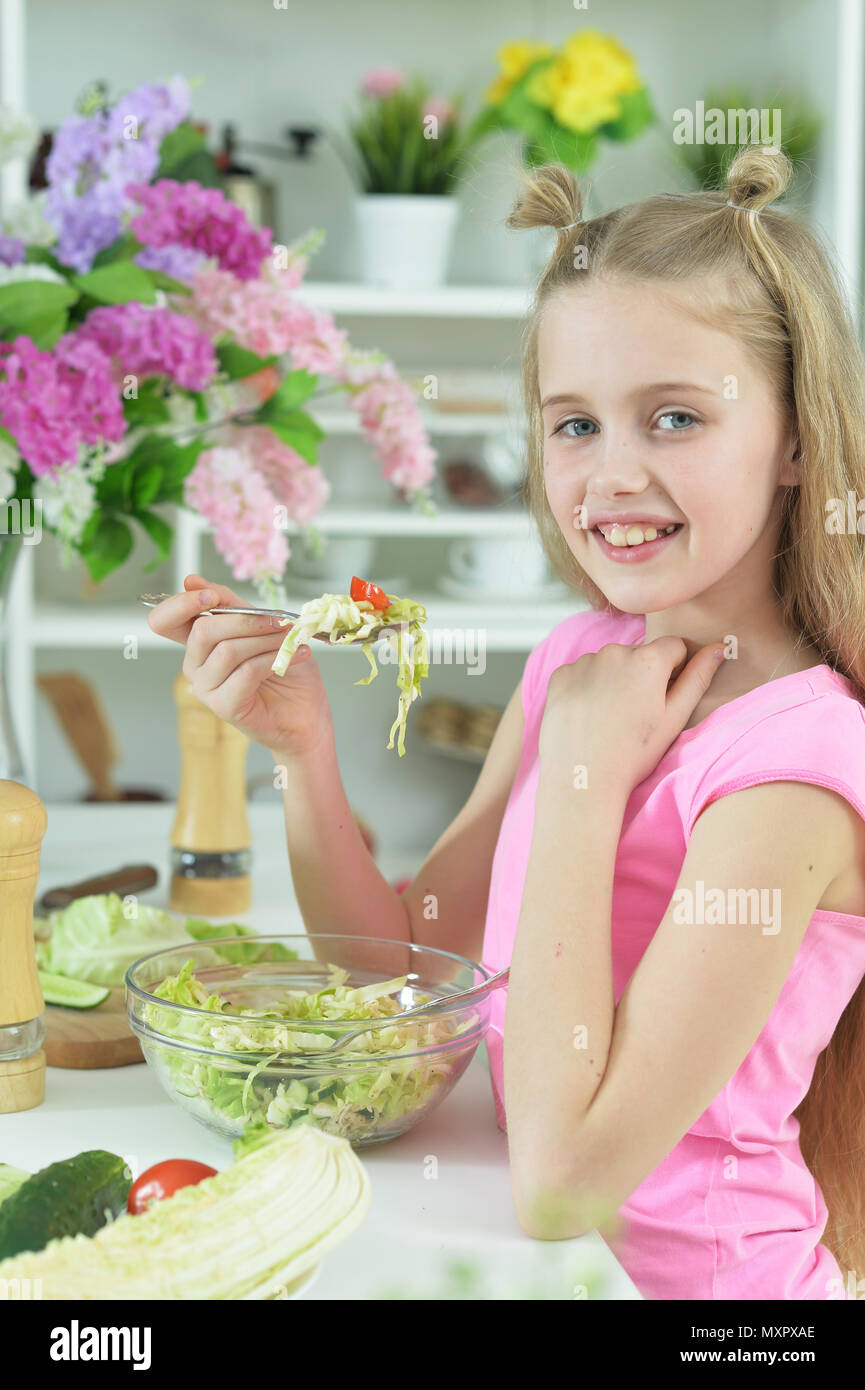 Cute girl eating delicious fresh salad Stock Photo - Alamy