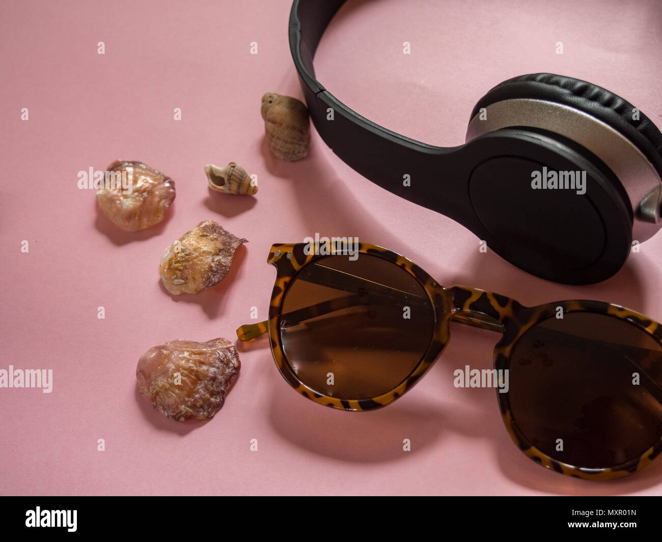 Sunglasses, earphones and seashells on pink background - Summer concept ...