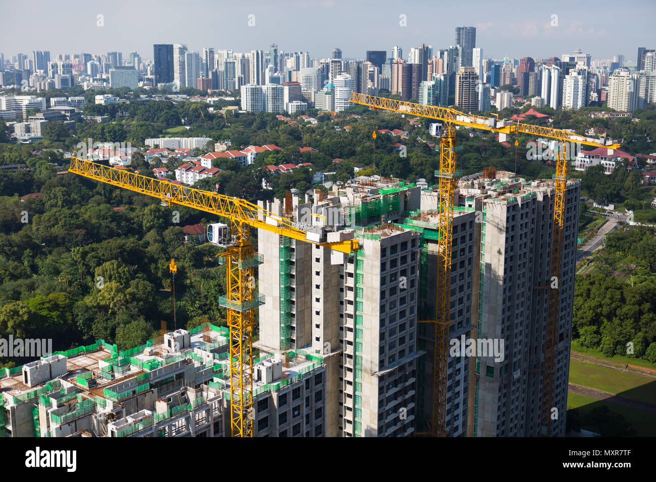 A close-up view of three yellow tower cranes in the urban area building ...