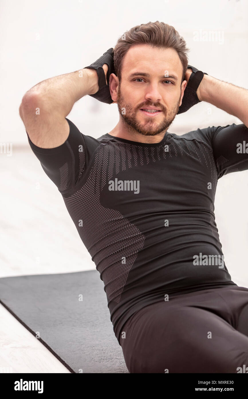Portrait of young man doing sit-ups on the floor in a gym Stock Photo ...