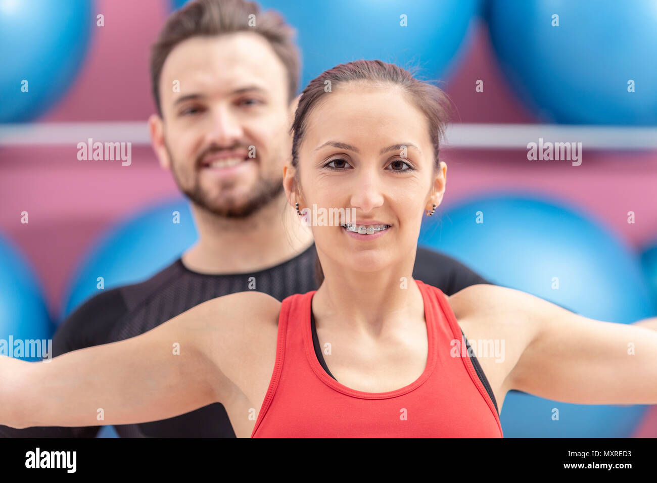 Portrait of a fit couple in a gym. Slective focus on the woman with ...
