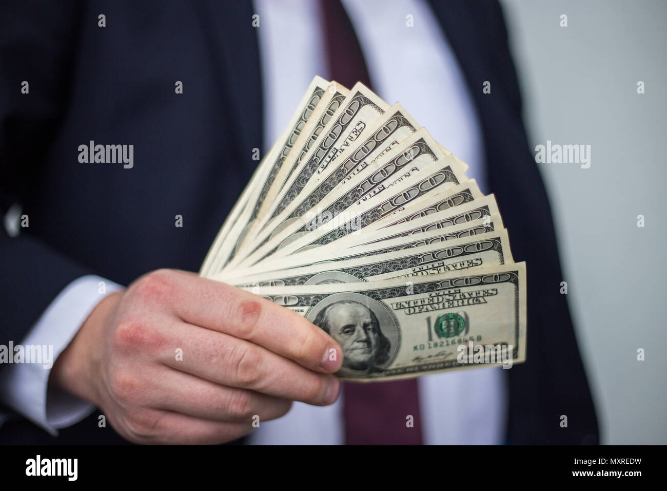 Business Man Displaying a Spread of Cash over a white vintage ...