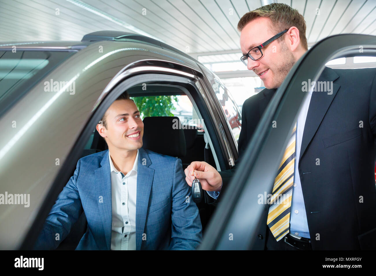 Customer buying new car in auto dealership Stock Photo - Alamy