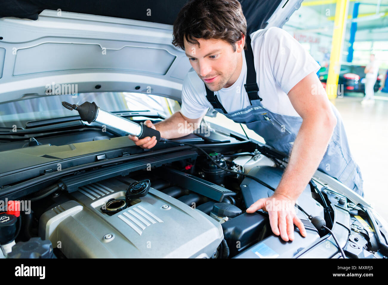 Auto mechanic working in car service workshop Stock Photo - Alamy