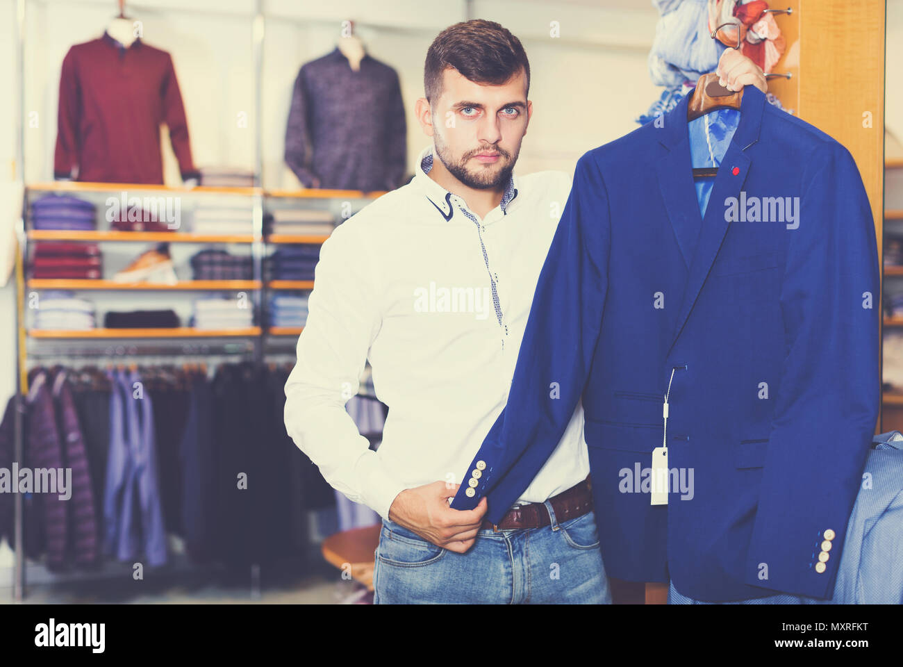 adult owner guy displaying jacket in fashion store Stock Photo - Alamy