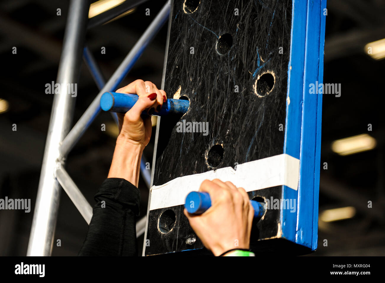 An Alpha Warrior competitor climbs a peg board while completing an ...