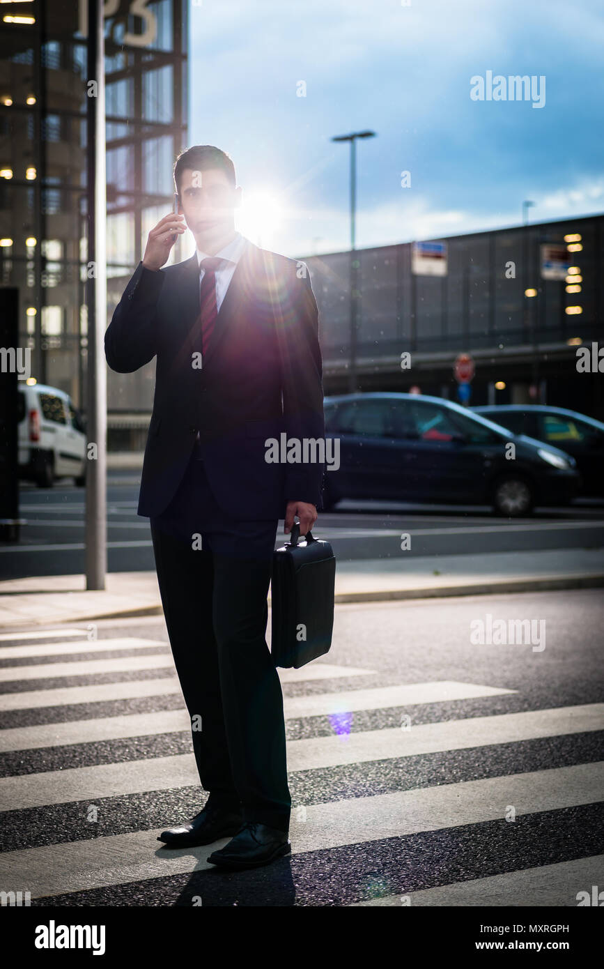 Business man using phone in evening outdoors Stock Photo - Alamy