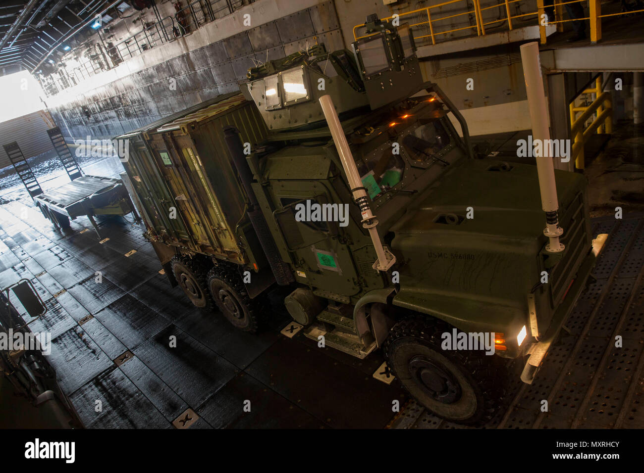 Marines with Combat Logistics Battalion 24 on-load vehicles to the USS ...