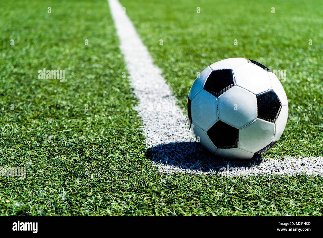 Black and white soccer ball on green soccer pitch Stock Photo - Alamy