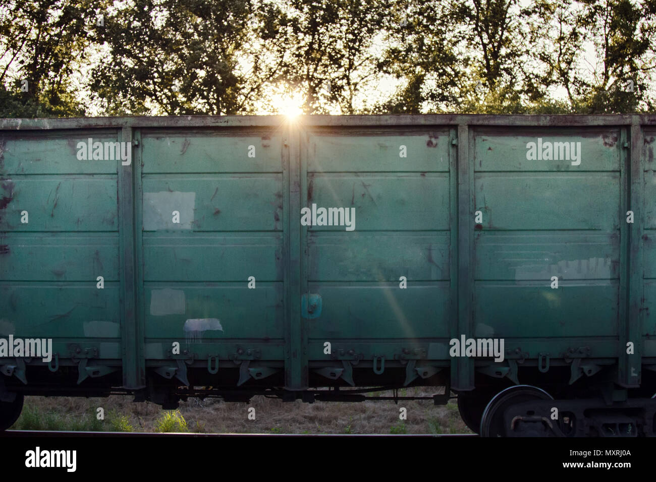 Railway wagon for bulk cargo, boxcar. Wooden wagon in rays of setting ...