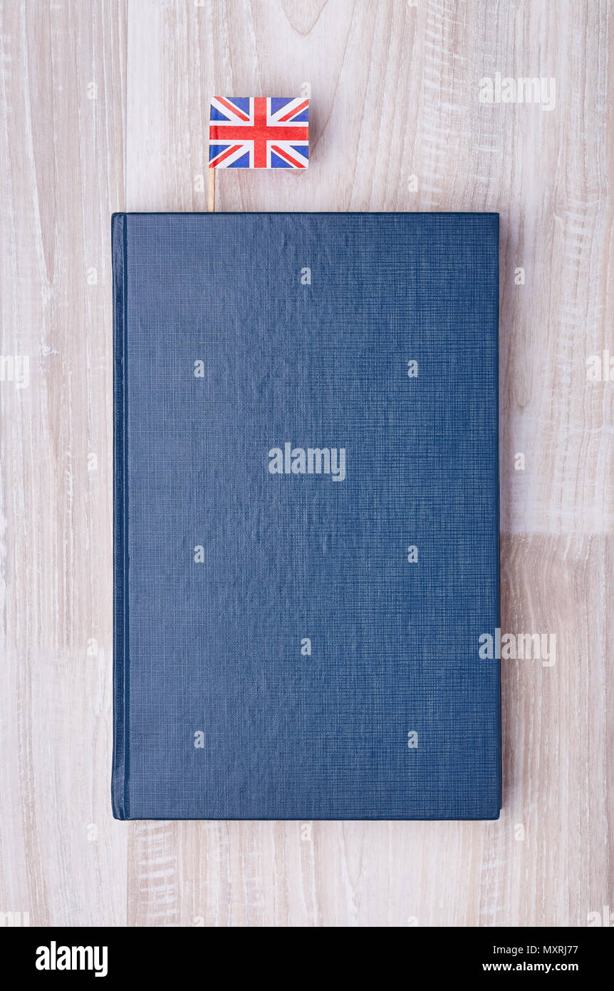 Flat lay of blue textured notepad with British flag on toothpick as ...