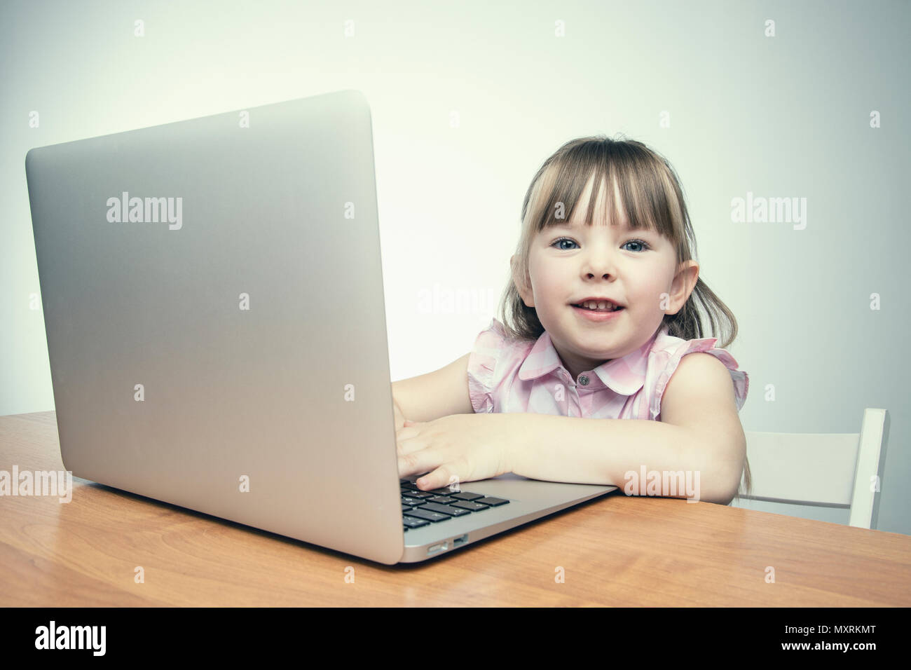 Little girl studying at the computer, distance learning during a ...