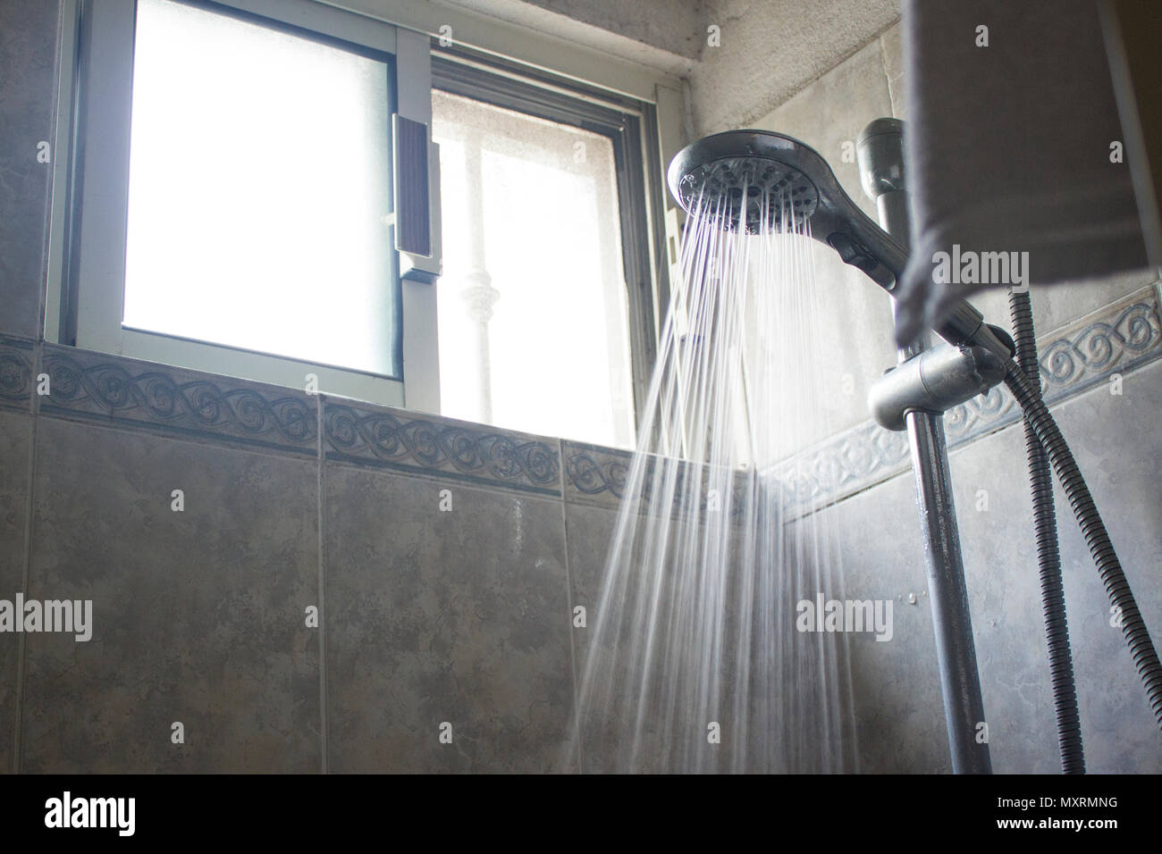 High pression water spray stream pouring from a handheld shower head ...