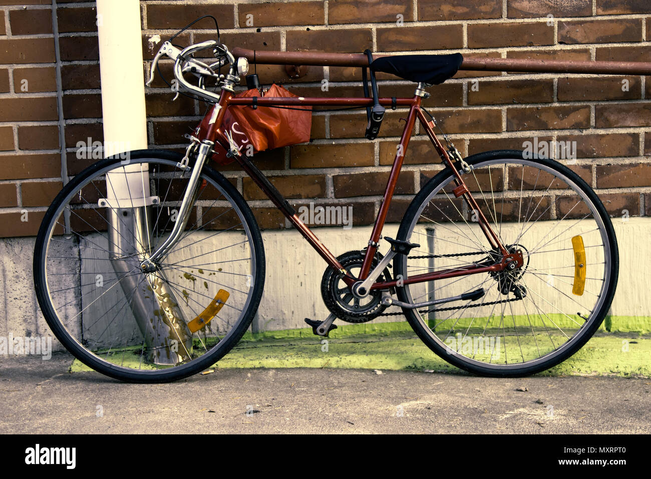 bike is fastened to brick wall, bike racks Stock Photo - Alamy
