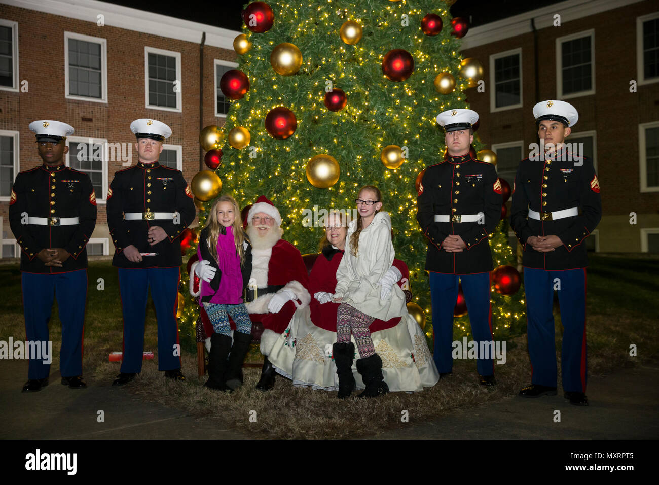 U.S. Marines and children pose for a picture with Santa and Mrs. Clause ...