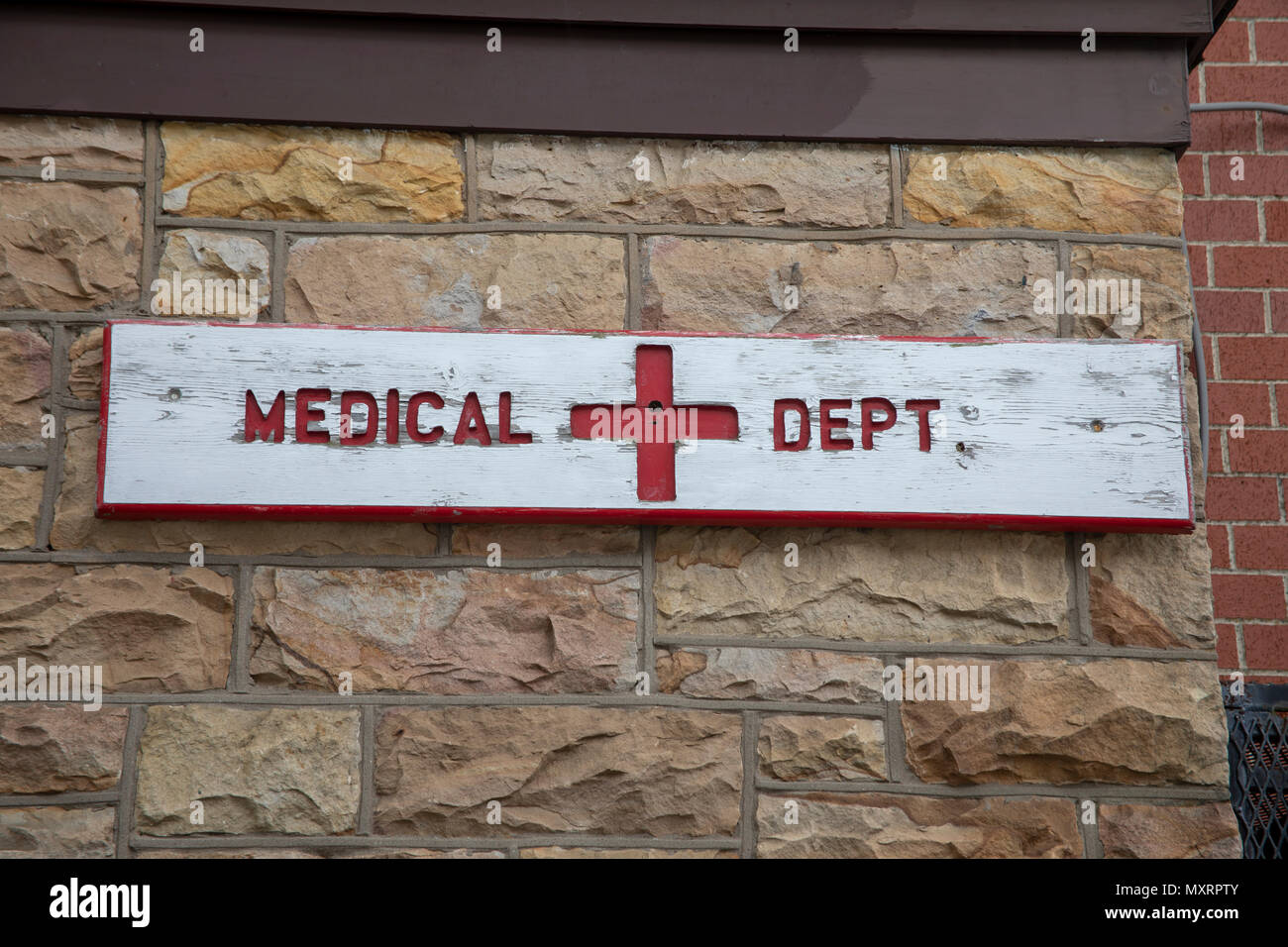 Wooden sign with medical department on brick wall exterior of old ...