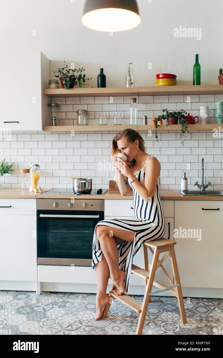Photo of beautiful woman in long striped dress in kitchen Stock Photo ...