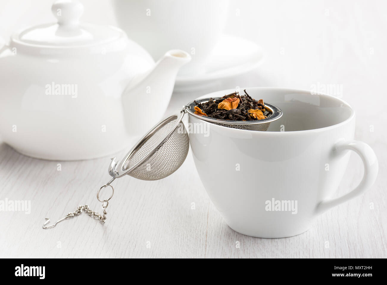 tea infuser opened on white cup with herbal mixture for tea Stock Photo ...
