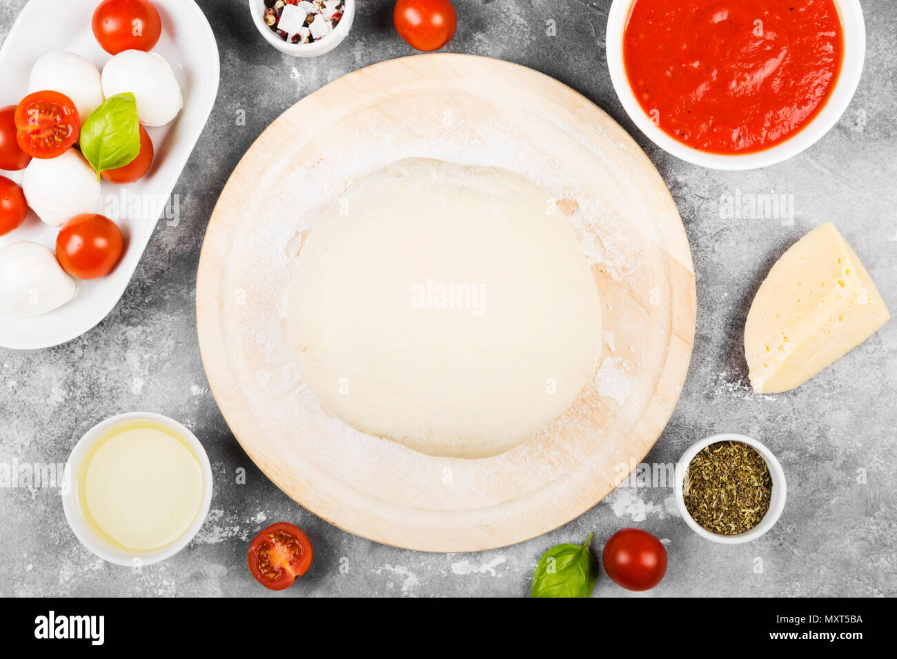 Pizza dough and ingredients for pizza on gray background. Top view ...