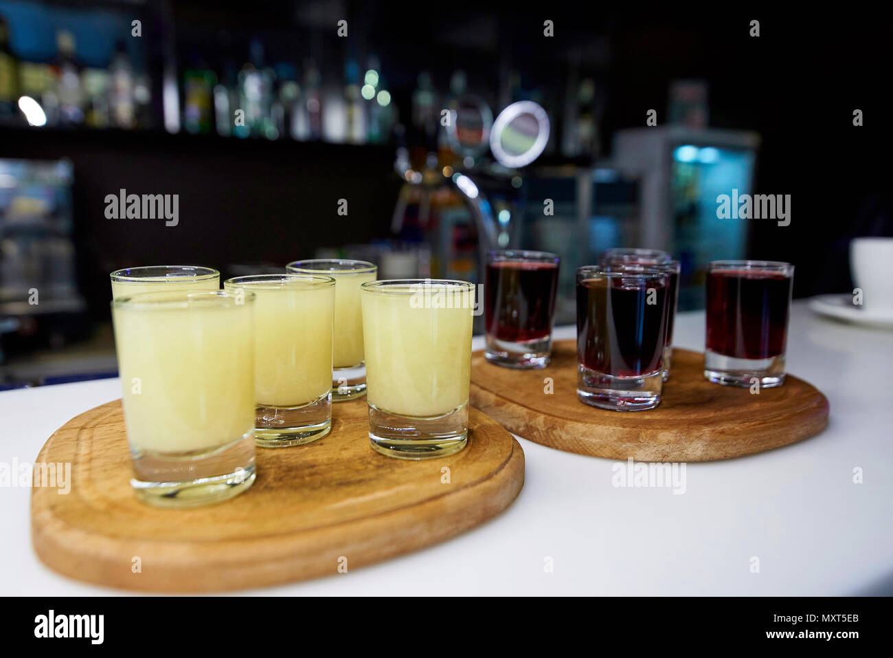 Alcohol shots on a wooden tray stand on the bar counter Stock Photo - Alamy