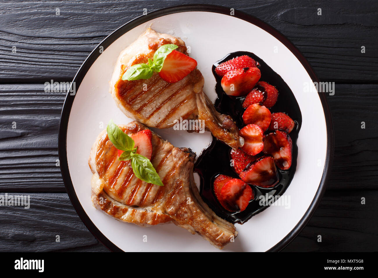 Hot grilled tasty pork chop with balsamic strawberry close-up on a ...