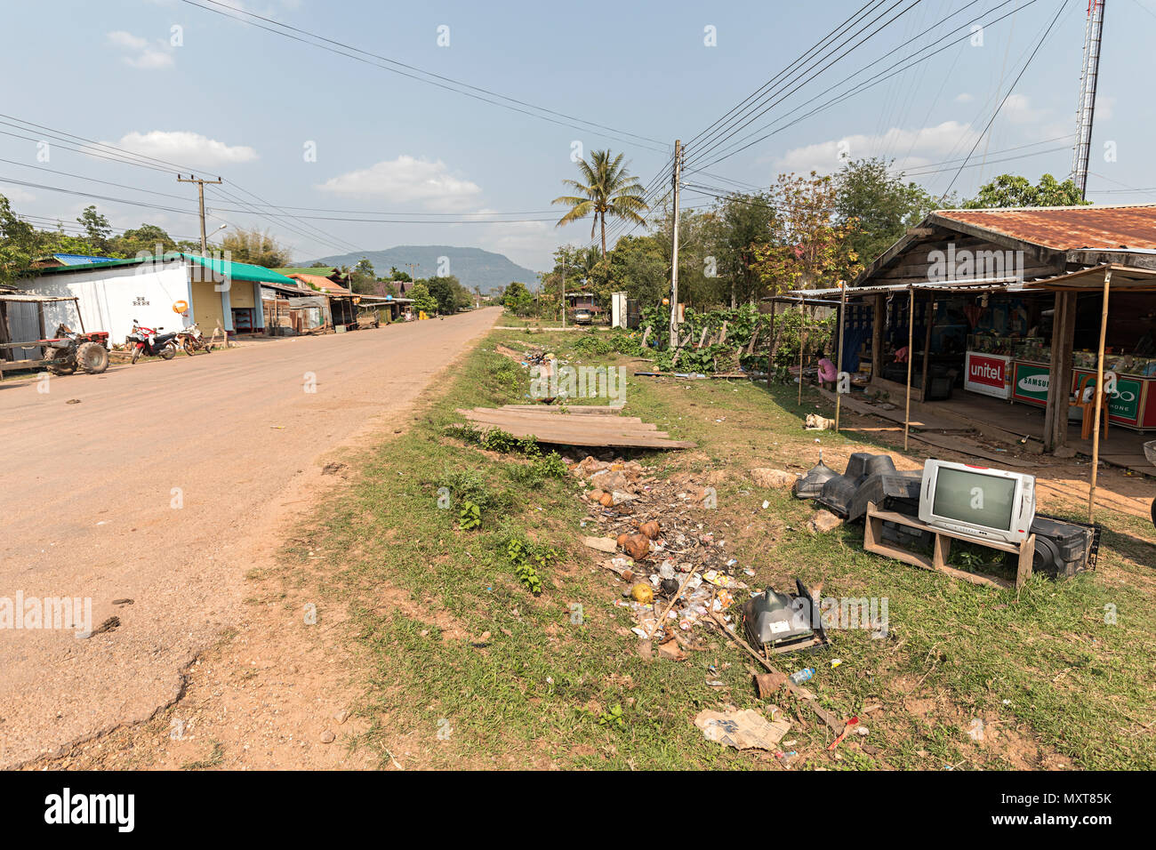 Road with shops through town of Boualapha with rubbish in ditch, Laos ...