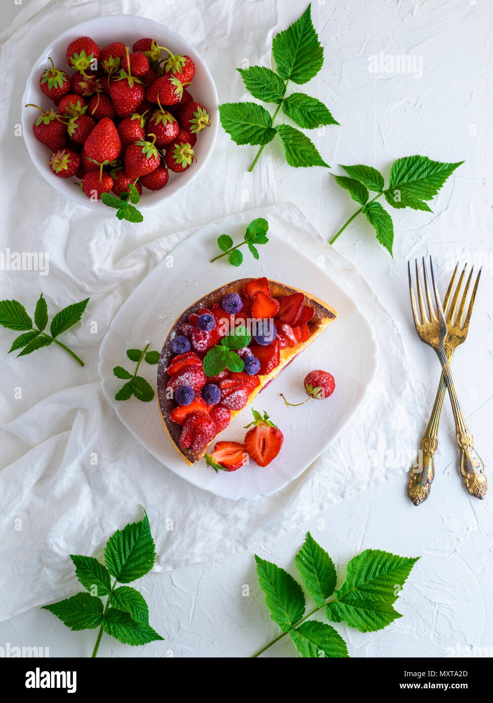 half a pie from cottage cheese and fresh strawberries, near two iron ...