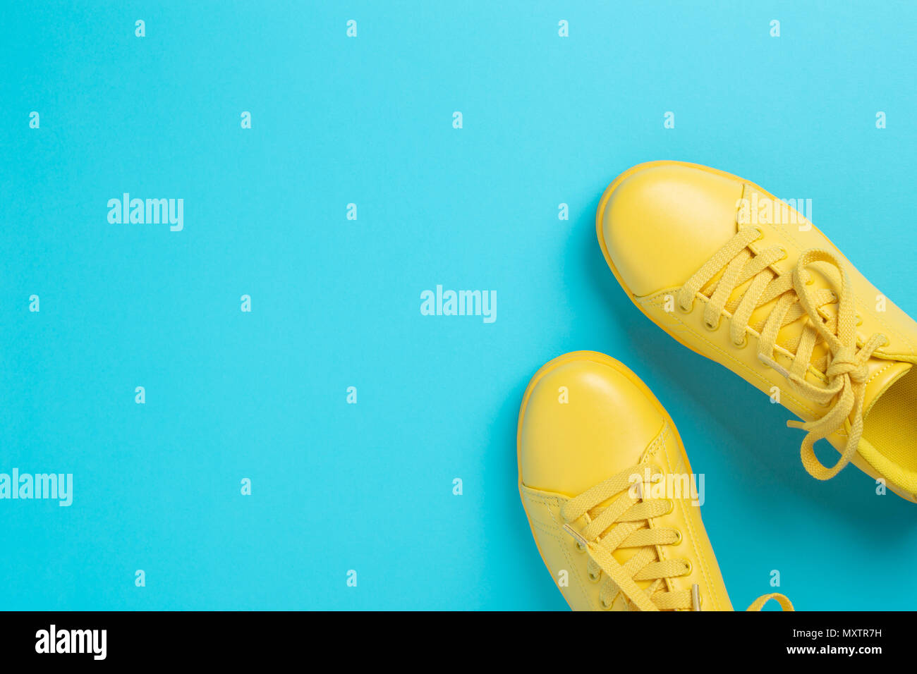 Pair of yellow shoes on blue background. Trendy summer color Stock ...