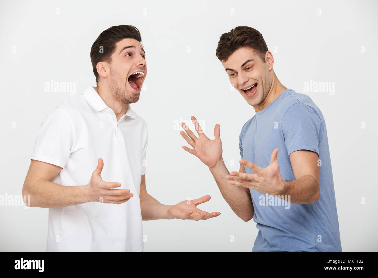 Portrait of two excited young men laughing isolated over white ...