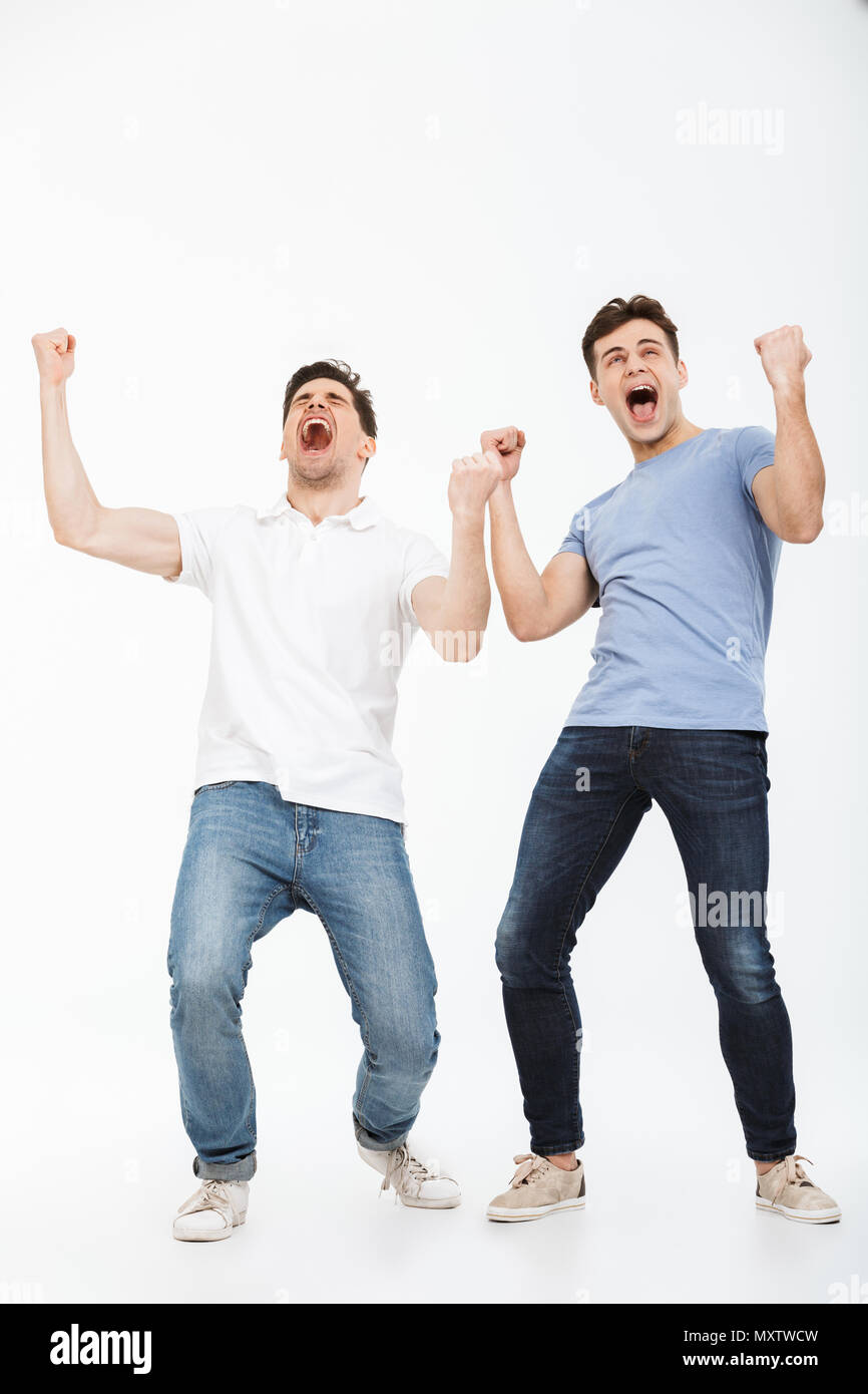 Full length portrait of two happy young men celebrating success ...