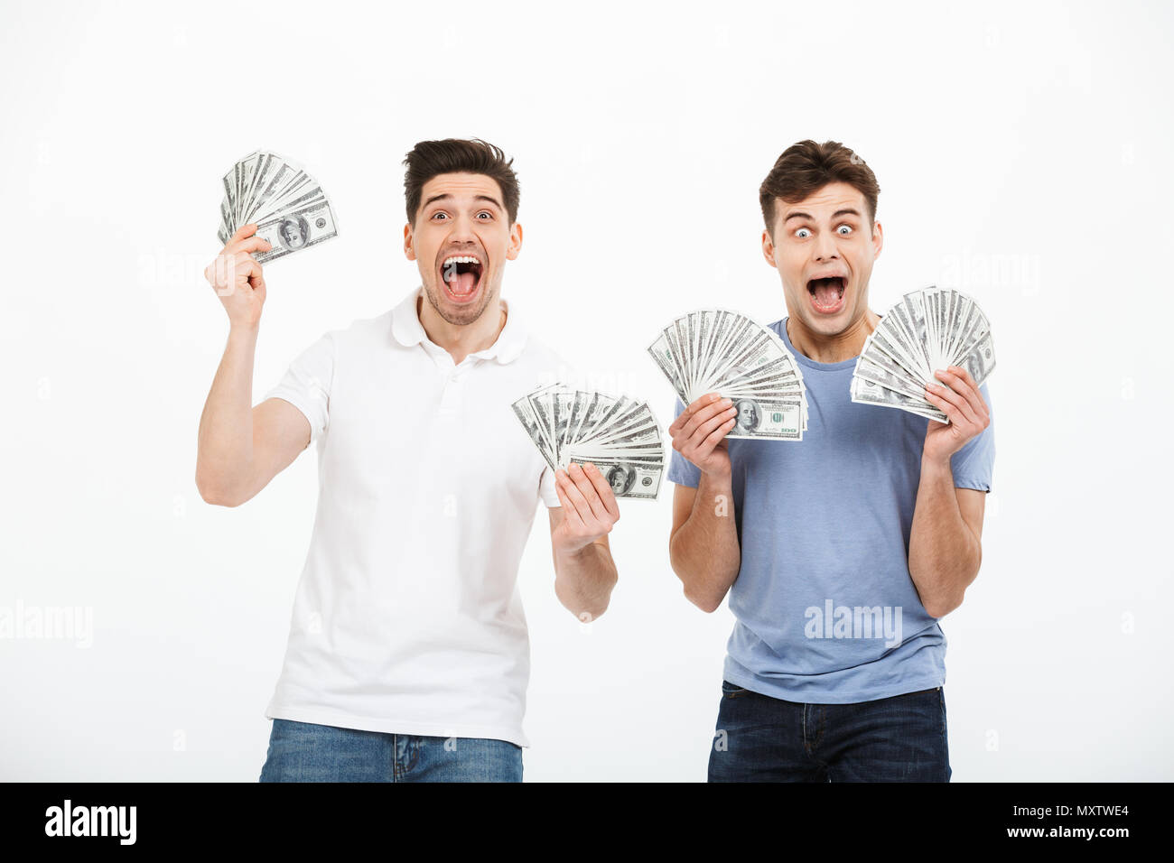 Portrait of two satisfied young men showing money banknotes and ...